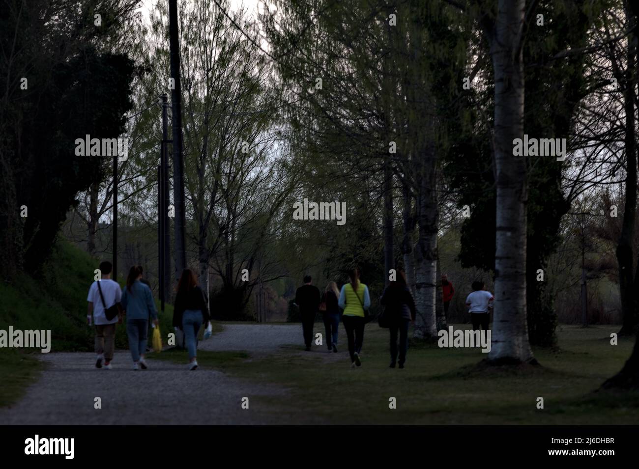 People walking on a path in a park at dusk Stock Photo - Alamy