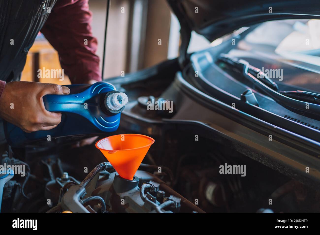 Mechanic pouring new oil into the engine Stock Photo - Alamy
