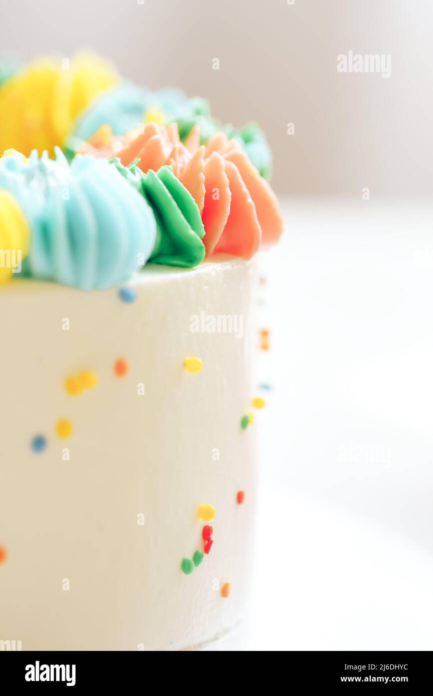 Vertical background of white cake with colorful cream close up Stock ...