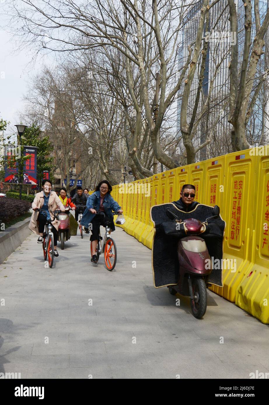 A Chinese man riding his scooter in a designated bicycle lane in ...