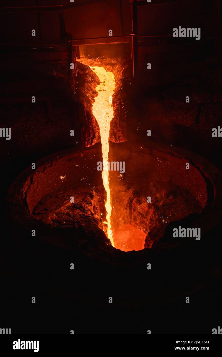 A stream of molten slag is poured into a metallurgical ladle Stock ...