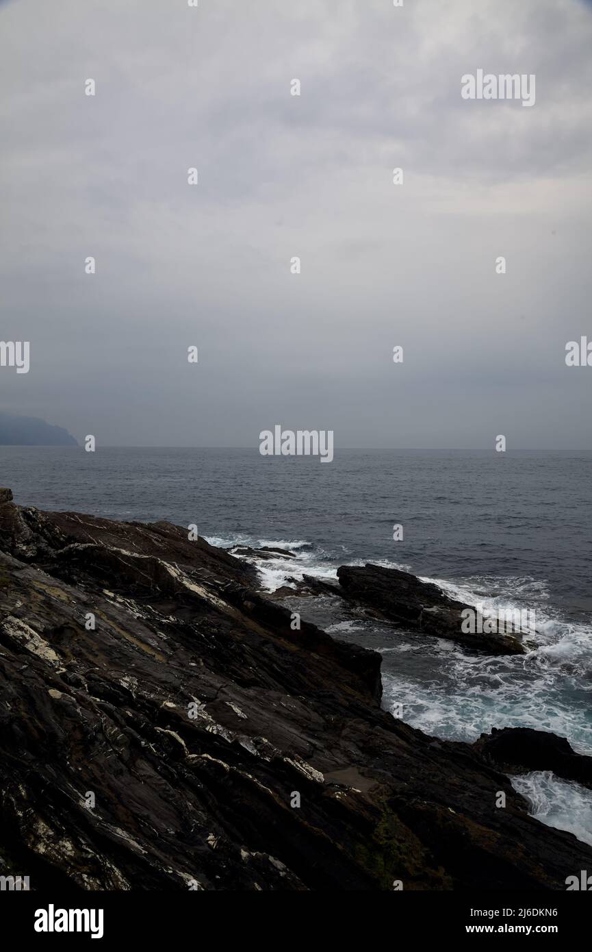 Cliff by the sea on a rainy and cloudy day Stock Photo - Alamy