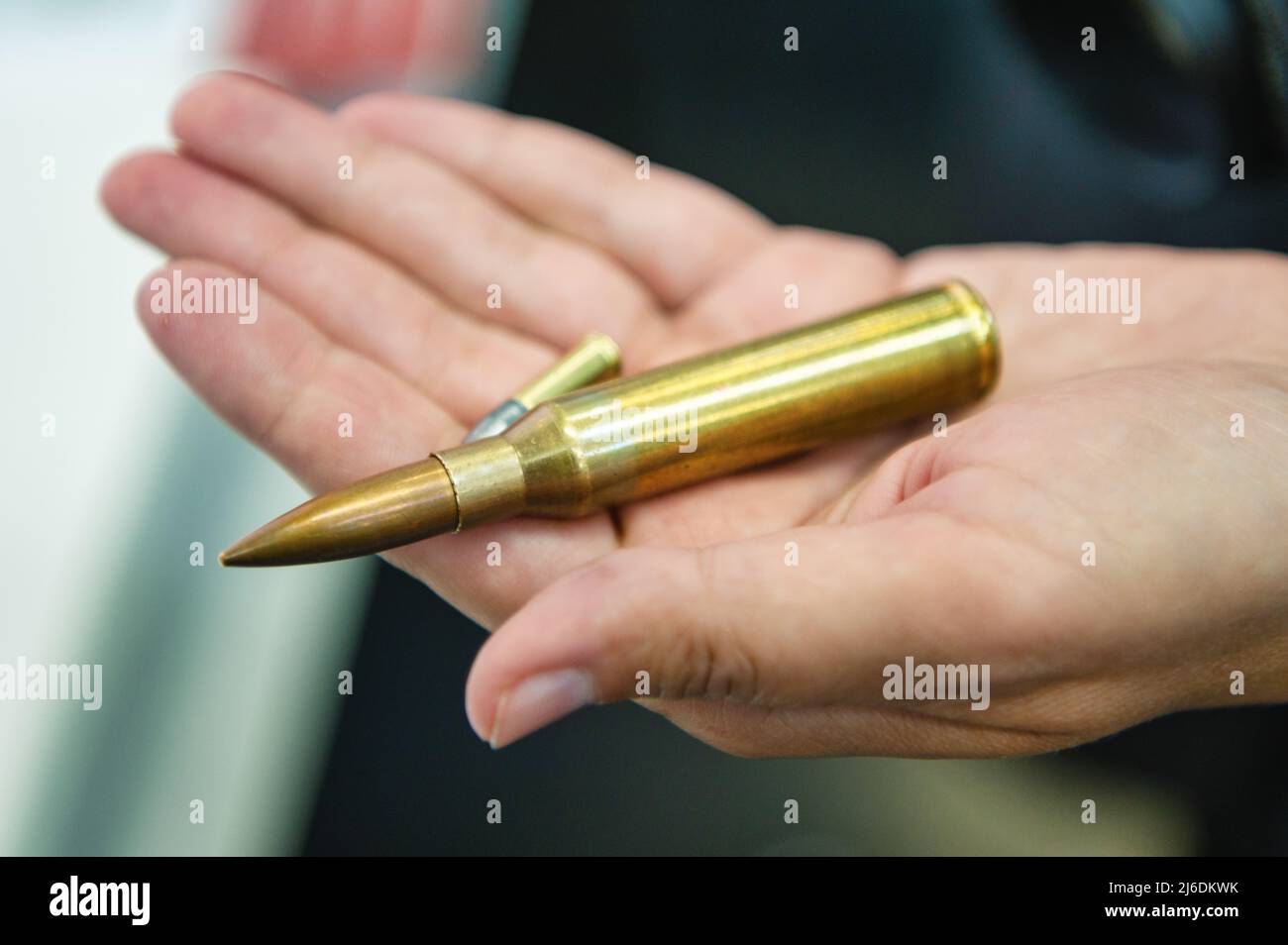 Hand holds small caliber and kalashnikov gun bullets closeup Stock ...