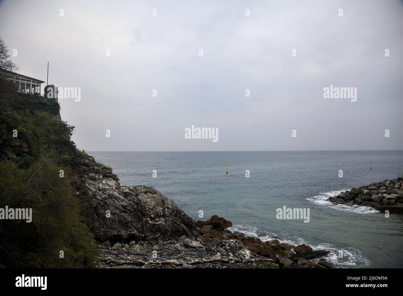 Houses on a cliff by the sea on a cloudy and rainy day Stock Photo - Alamy