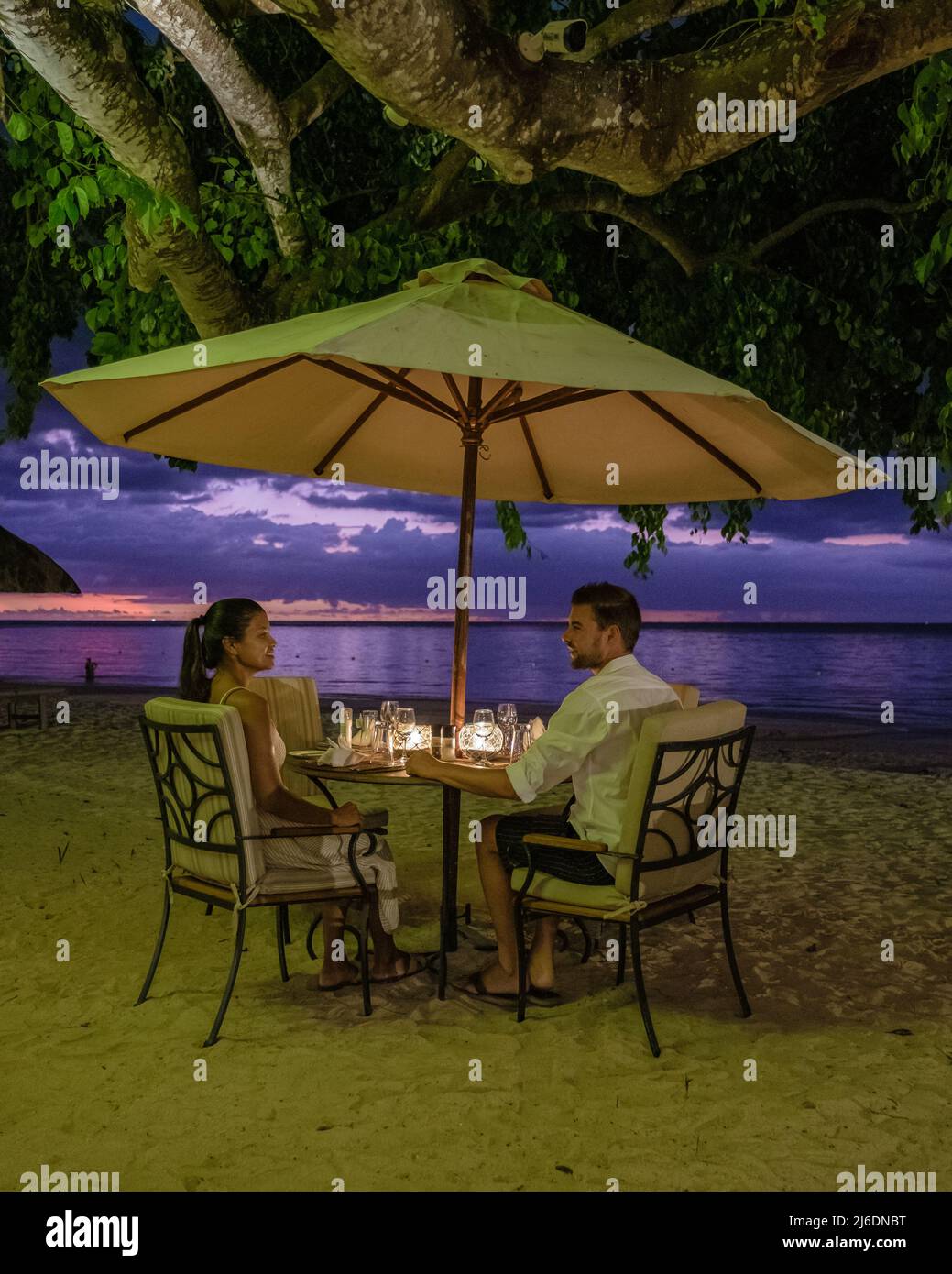 sunset on the beach in Mauritius, a luxury restaurant with umbrellas ...