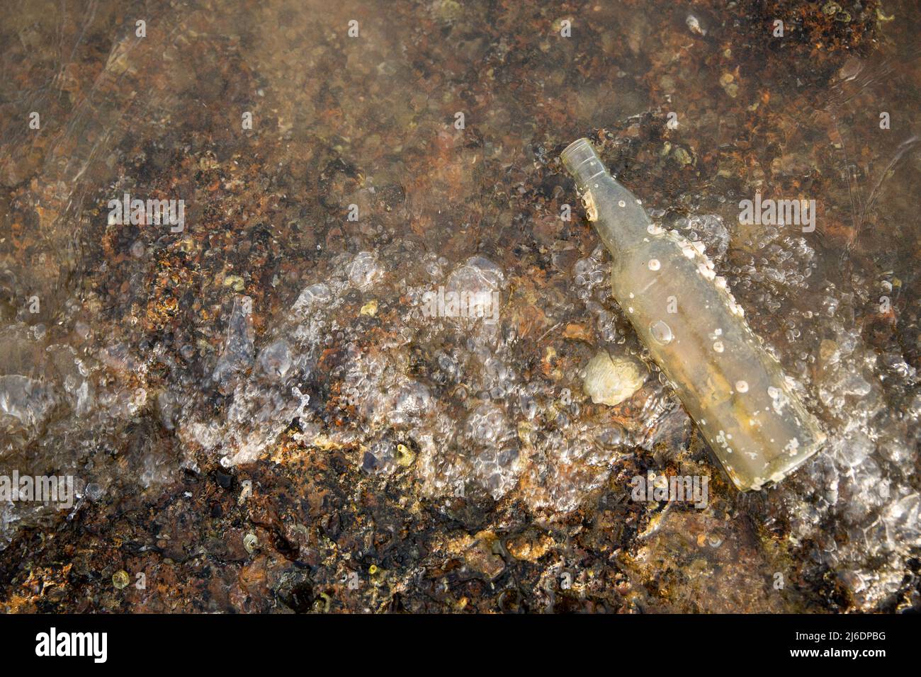 Bottled water washed away by seawater, marine debris Stock Photo - Alamy