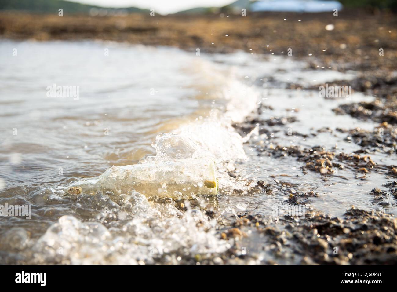 Bottled water washed away by seawater, marine debris Stock Photo - Alamy