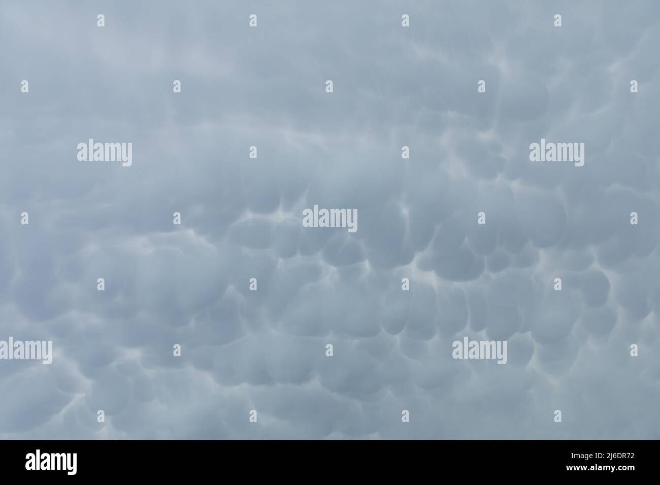 A wide patch of sky strewn with storm clouds in the shape of bubbles ...