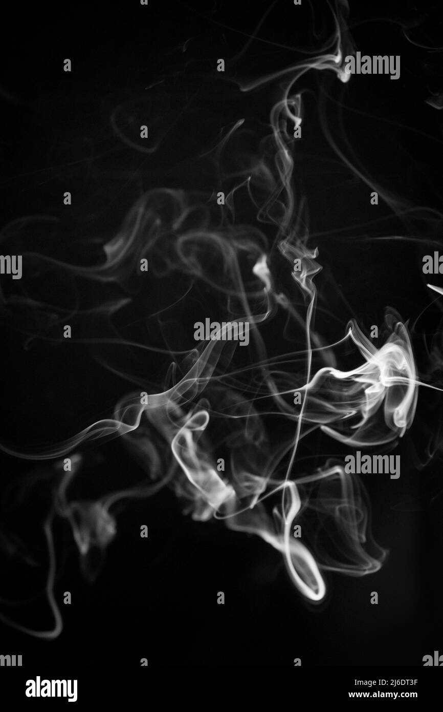 A black and white swirling, ascending smoke pattern on a black ...