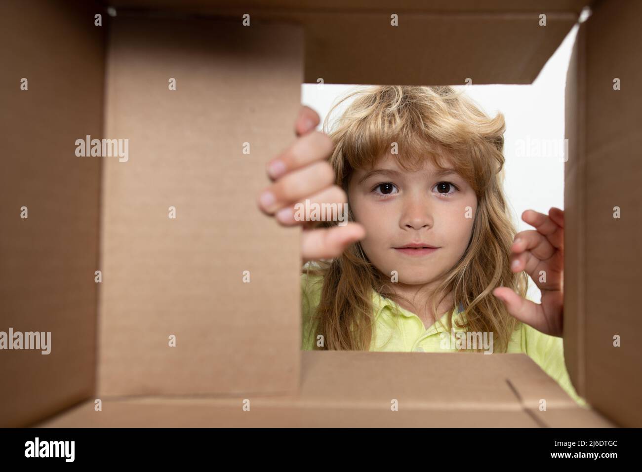 Cheerful cute child opening a present. View from inside of the box ...