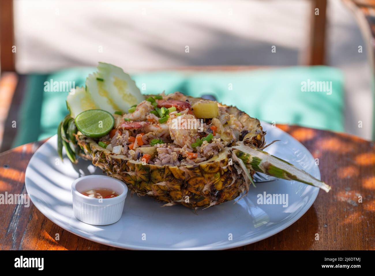 Cooked brown rice with vegetables and shrimp in a pineapple, close up ...