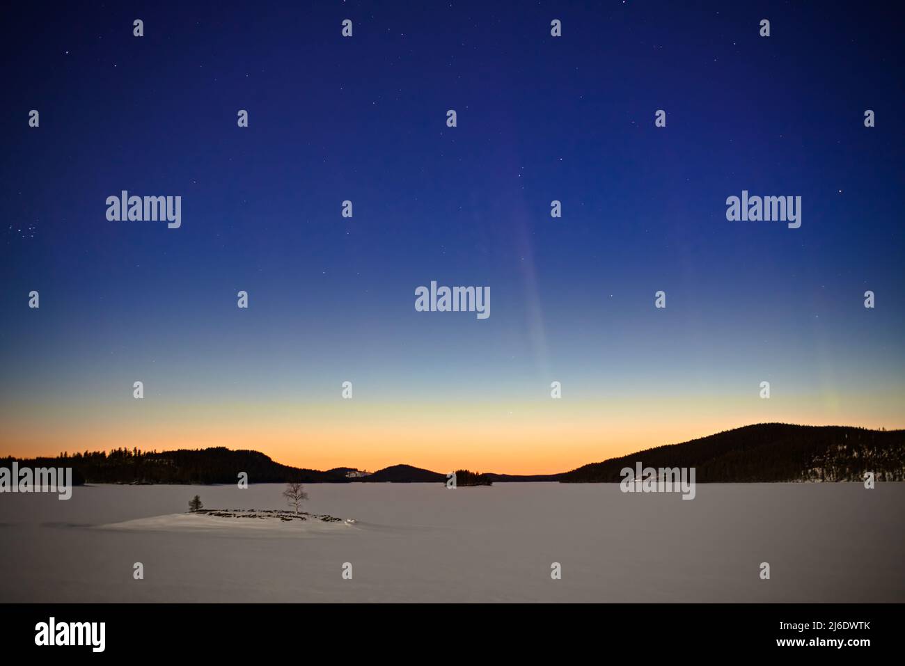 Subtle northern lights in dusk over frozen lake in Swedish Lapland ...