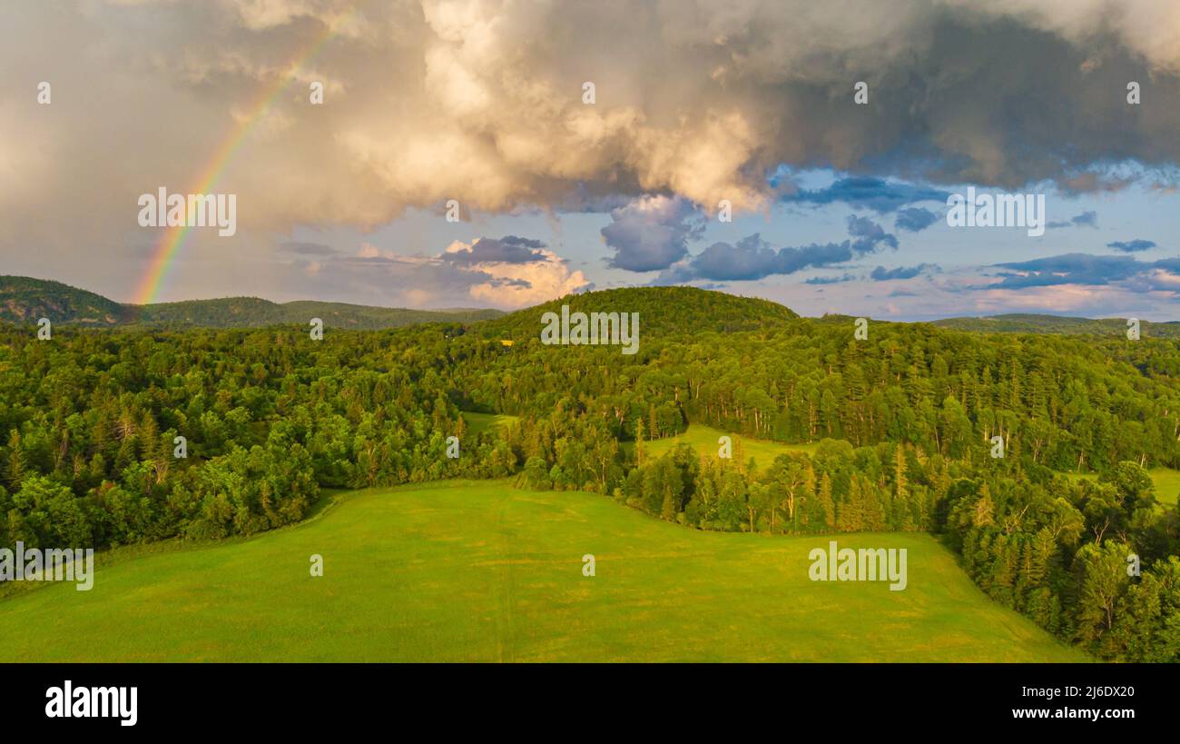 Rainbow over the wide endless horizon of Canada landscape. Green meadow ...