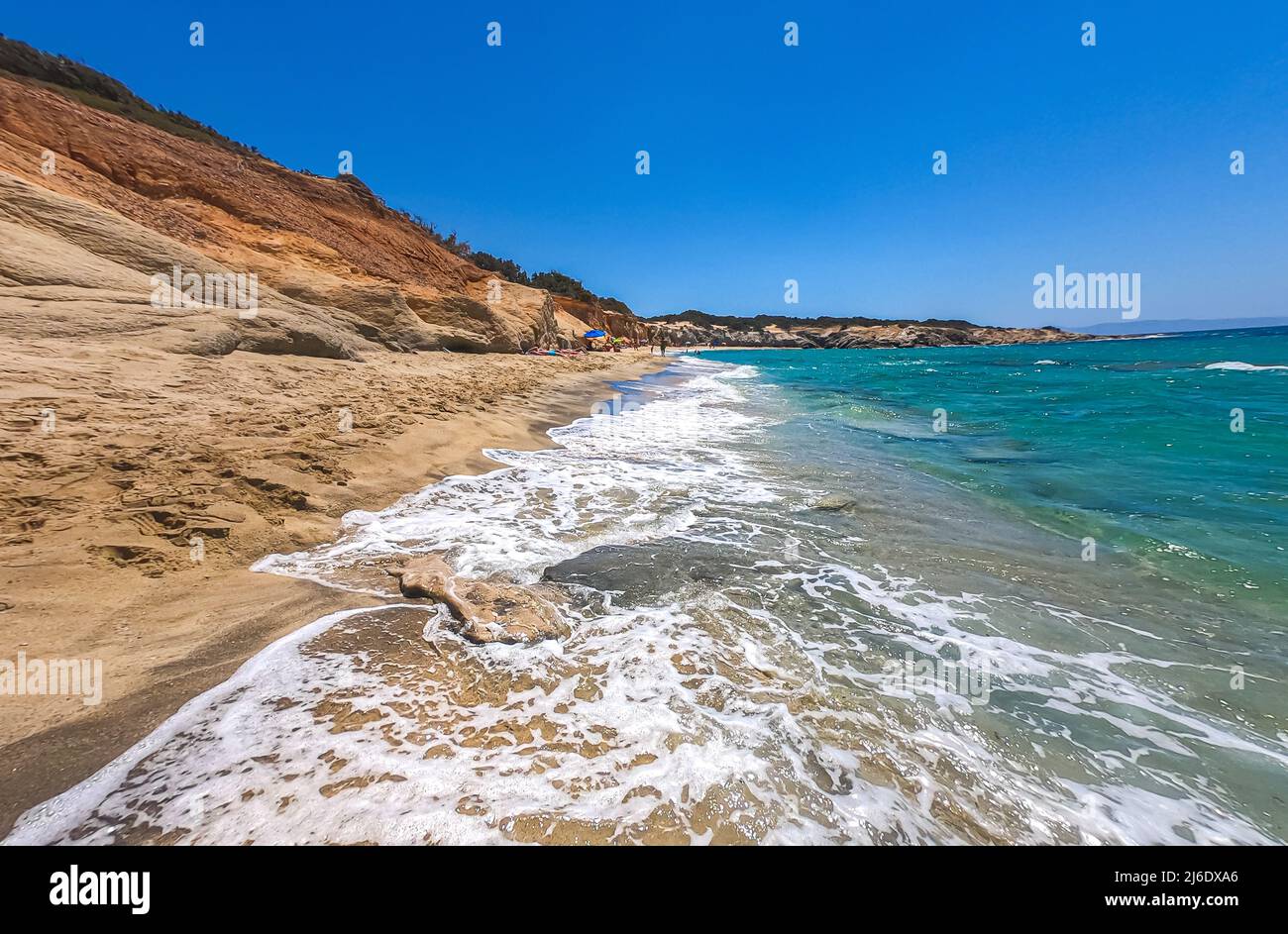 Beach at the cyclades island of Naxos. Turquoise water splashes on the ...