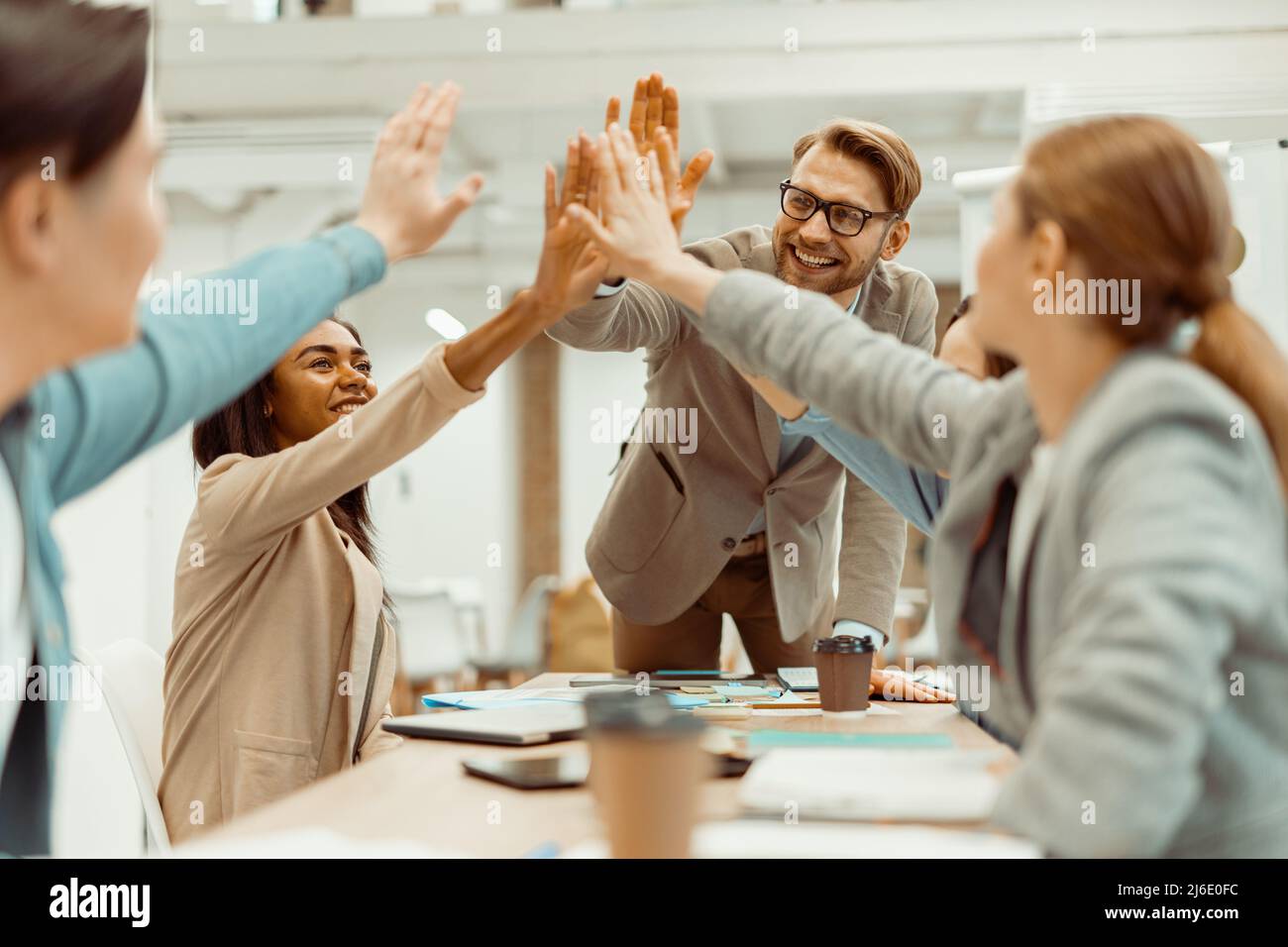 Young team putting hands up for new startup in the office Stock Photo ...