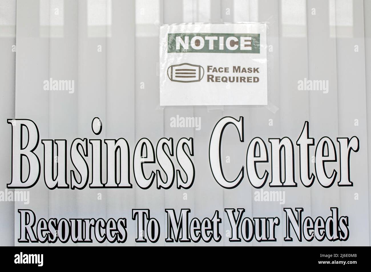 Face mask required sign taped on the window of a Business Center during ...