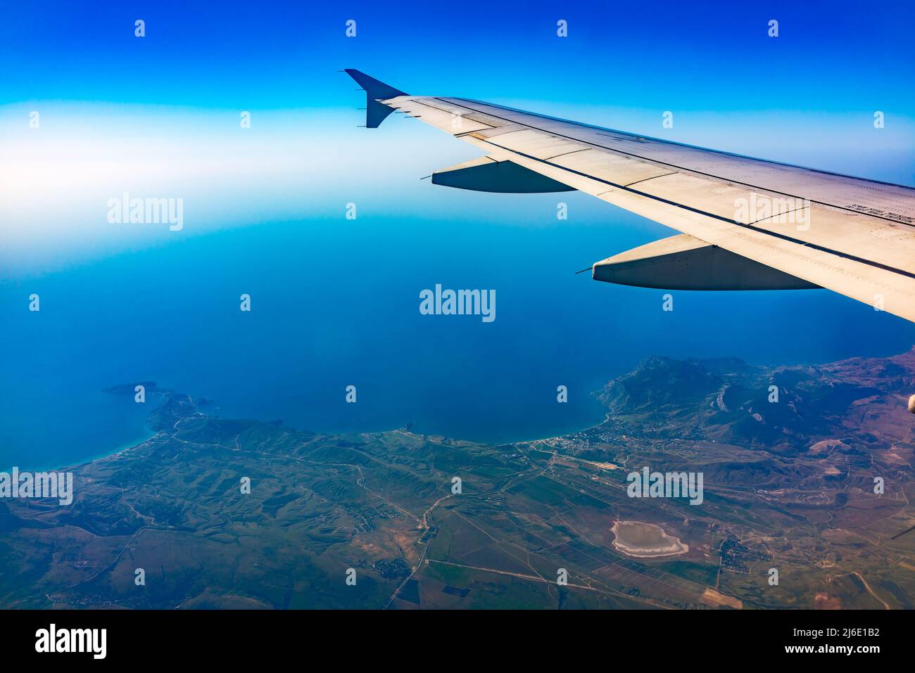 View from the airplane window at a beautiful blue clear sky, earth, sea ...