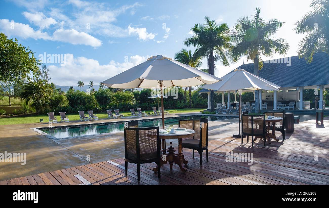 swimming pool with beach chairs and lunch table at a luxury resort ...