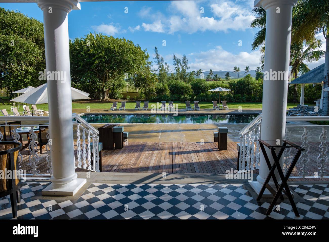swimming pool with beach chairs and lunch table at a luxury resort ...