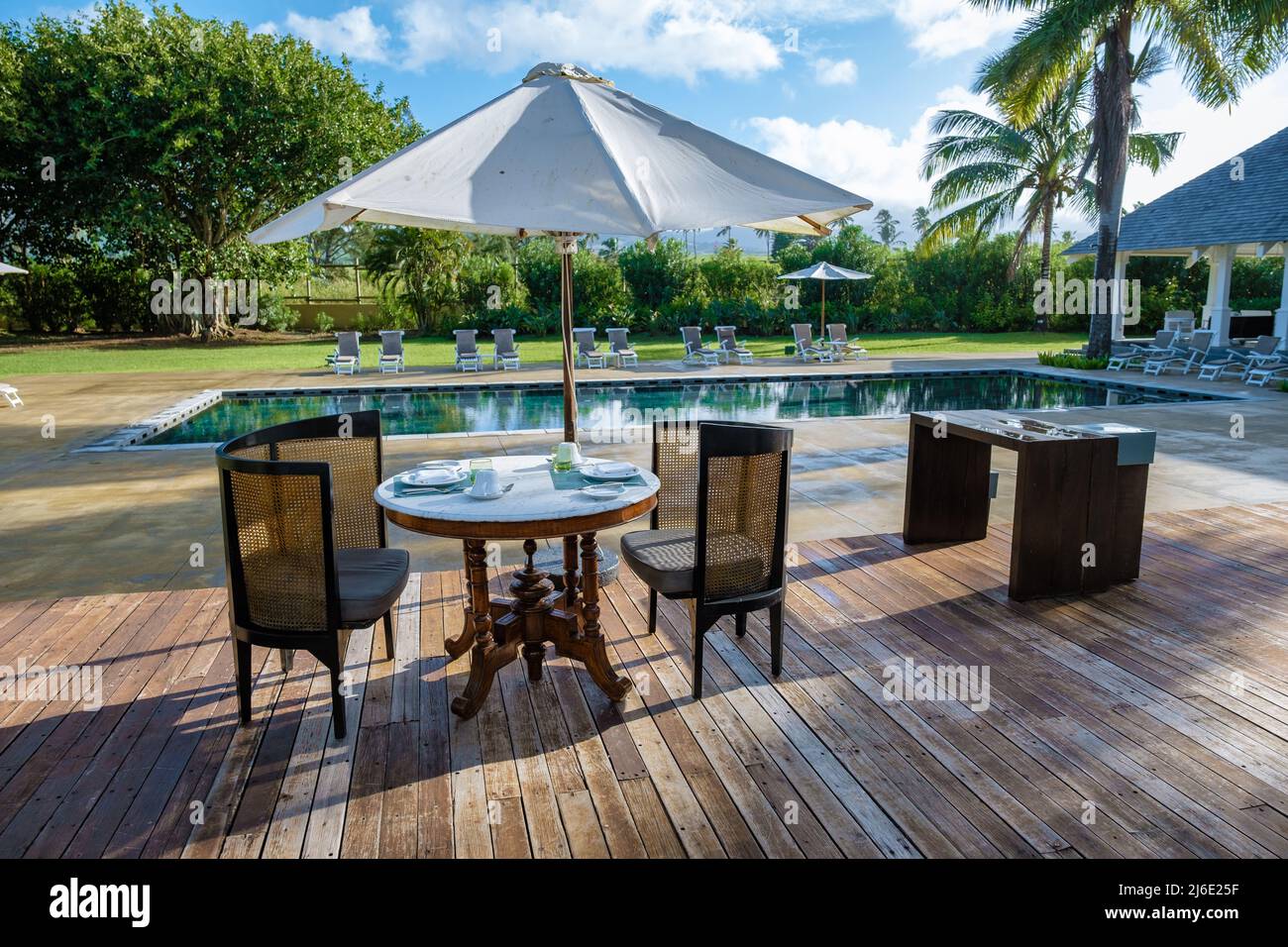 swimming pool with beach chairs and lunch table at a luxury resort ...