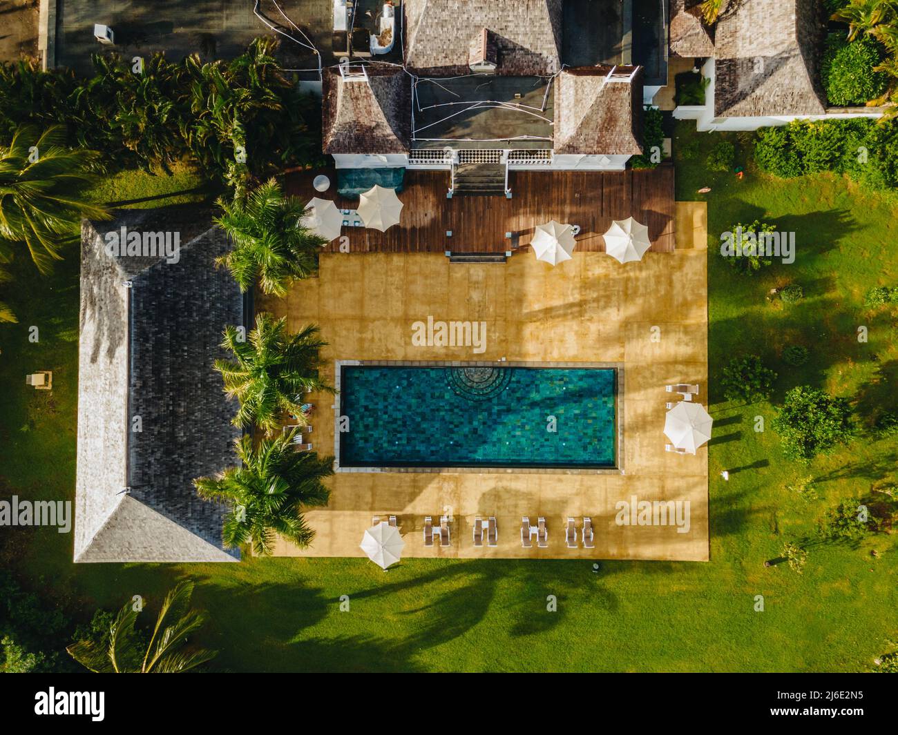 old plantation house with swimming pool and beach chairs by the ocean ...