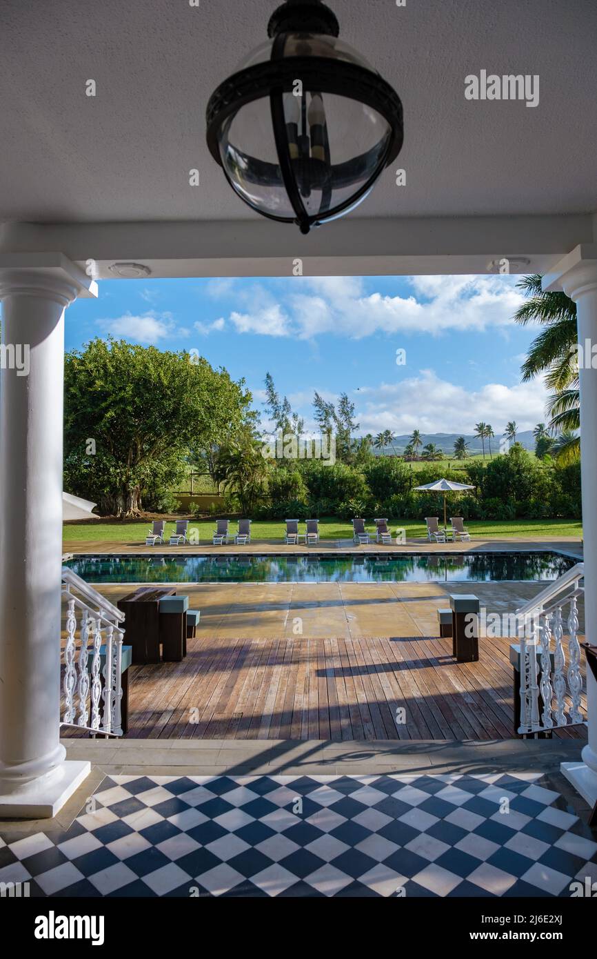 old plantation house with swimming pool and beach chairs by the ocean ...
