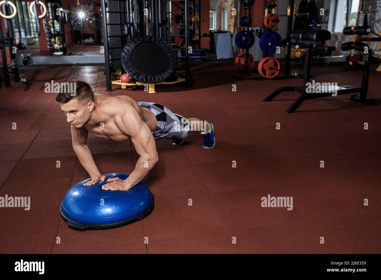 Muscular man doing push up on bosu ball at crossfit gym Stock Photo - Alamy