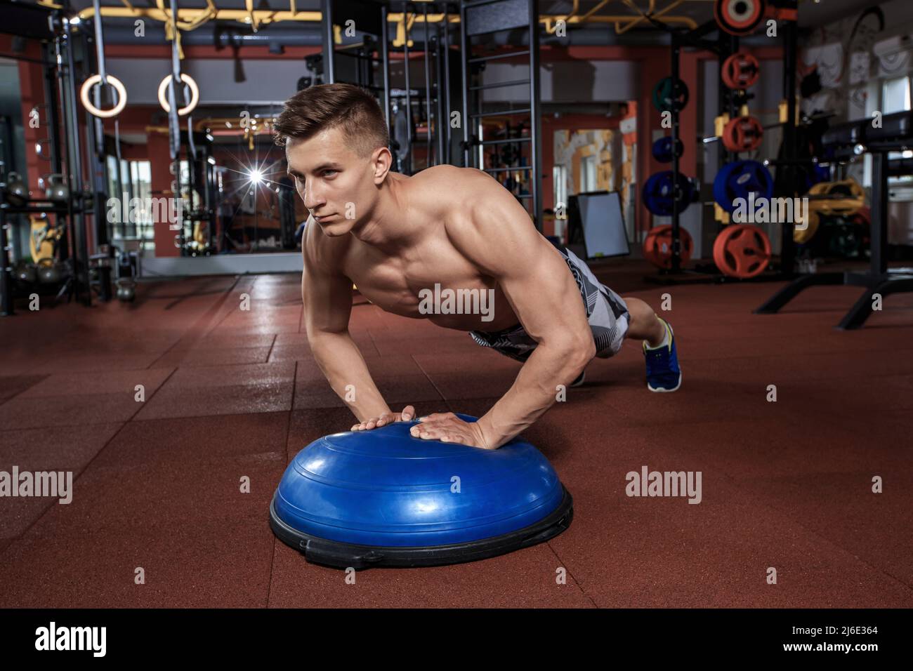Muscular man doing push up on bosu ball at crossfit gym Stock Photo - Alamy