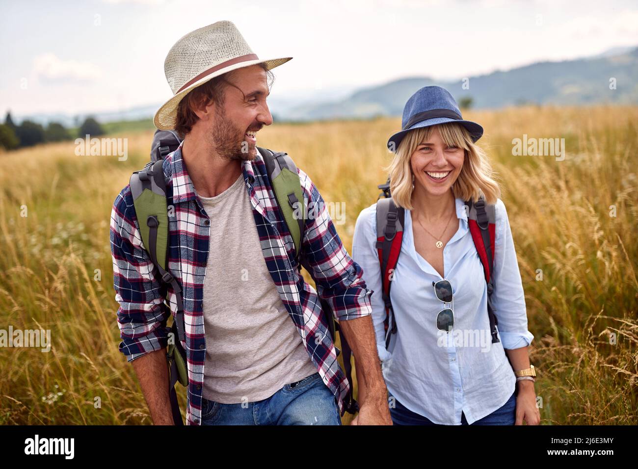 Jolly caucasian couple exploring countryside together on the field ...