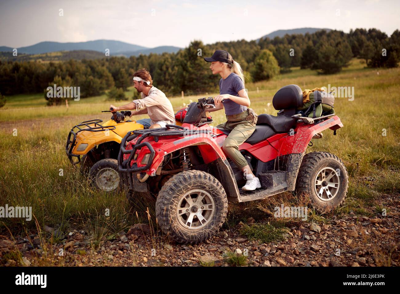 Two tourist friends driving quads together in the nature; Active ...