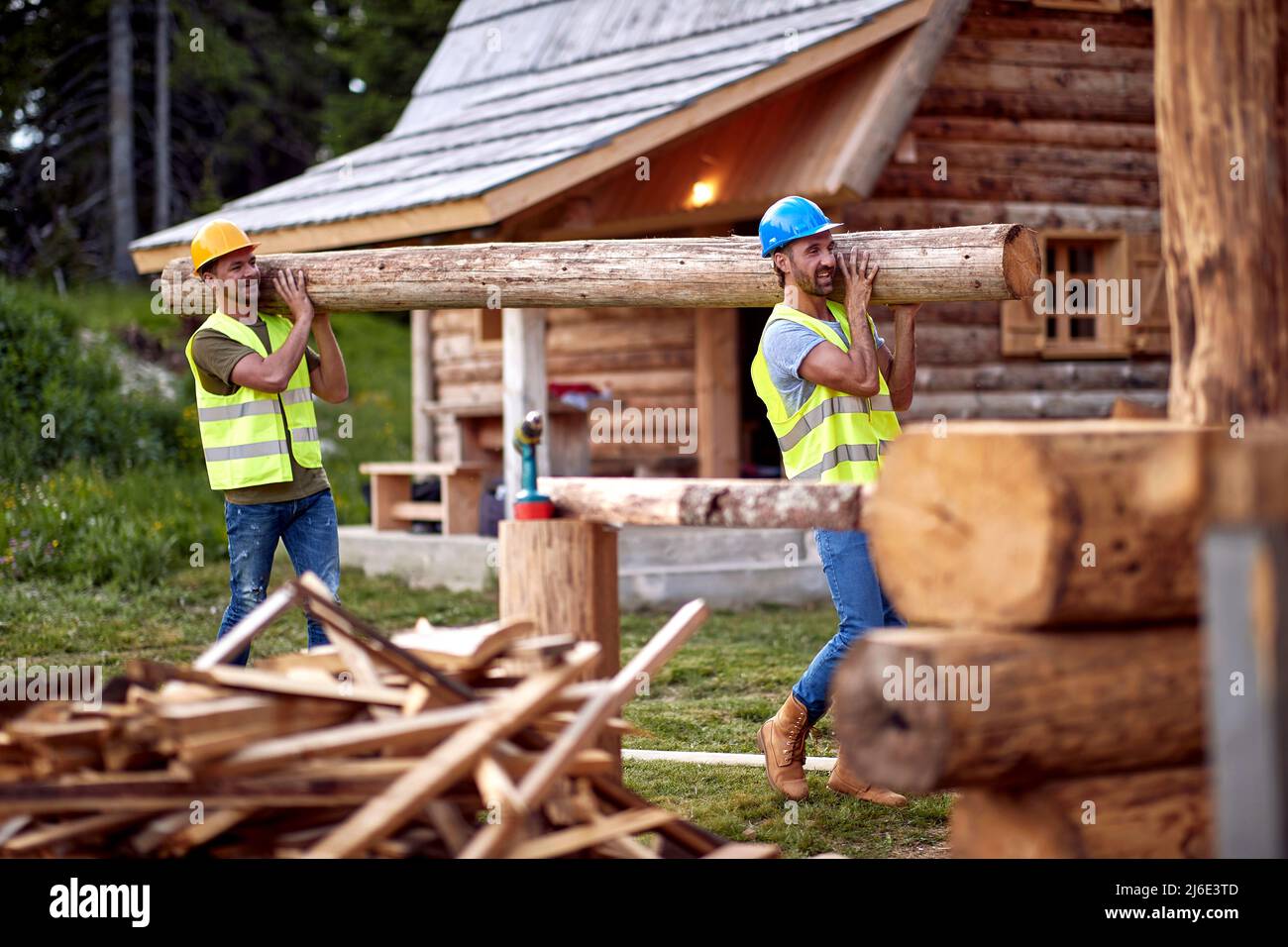 Teamwork .Smiling carpenters holds wooden planks on construction site ...