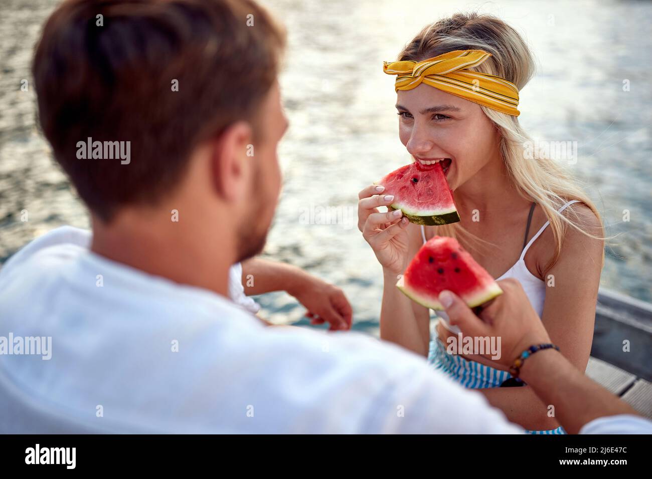 beautiful girl looks at the man in love and eats a watermelon by the ...