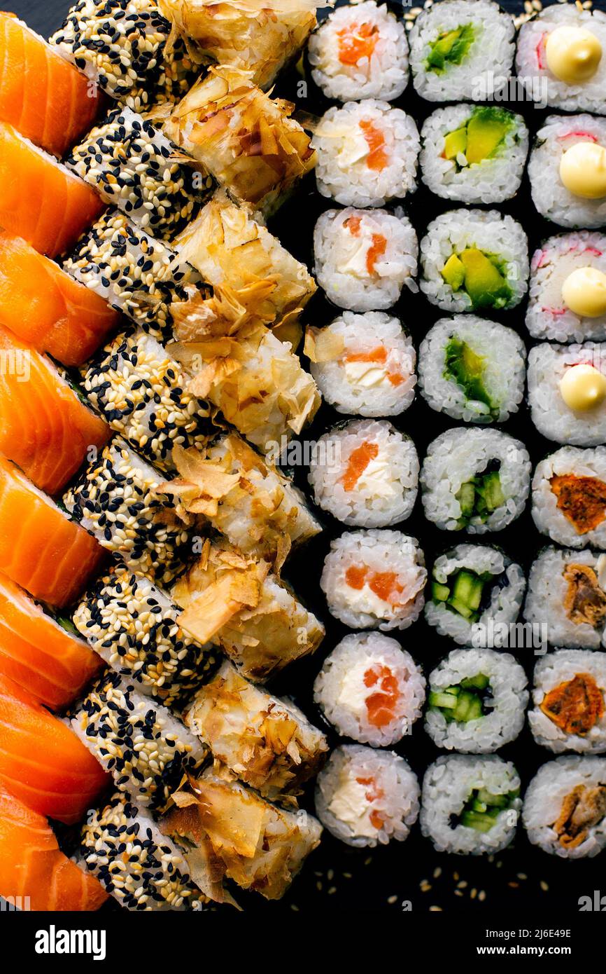 Assorted japanese sushi rolls on black background. Asian or Japanese ...