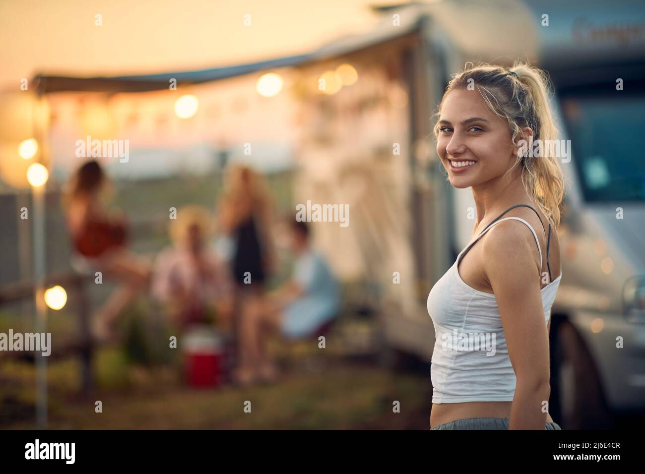 Smiling Girl in front of camper van.Travel and friendship celebration ...