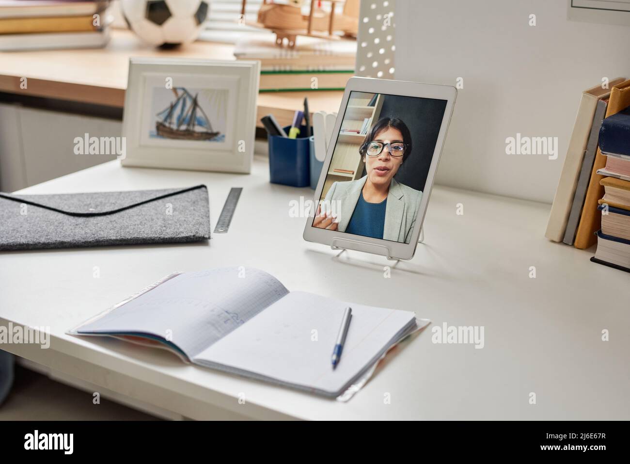 Focus on digital tablet with tutors portrait on table with open ...