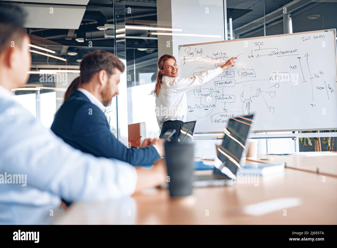 businesswoman explaining her business plan to colleagues while making a ...