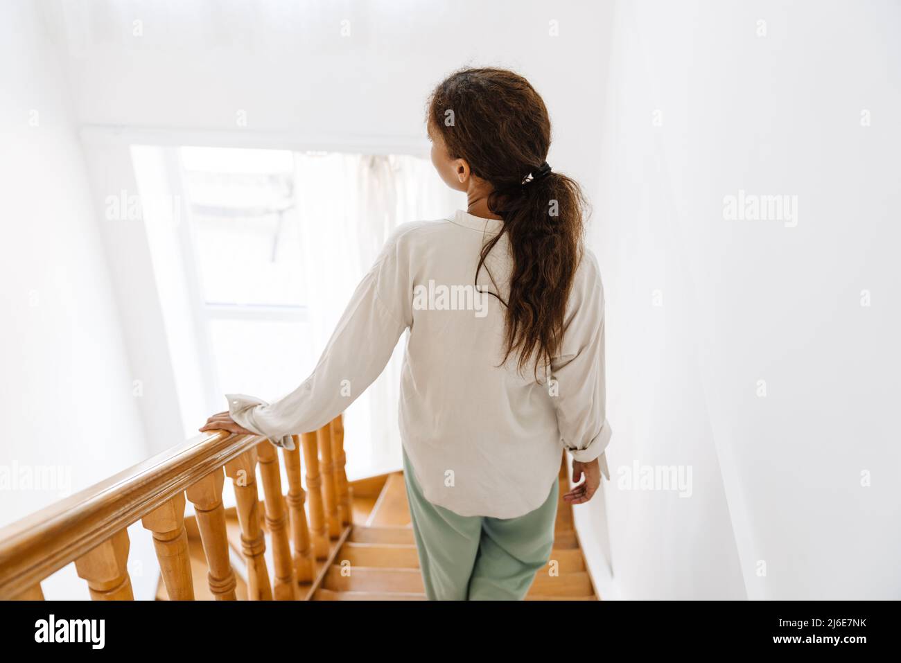 Young black woman wearing pajama walking downstairs at home Stock Photo ... Young black woman wearing pajama walking downstairs at home Stock Photo ...