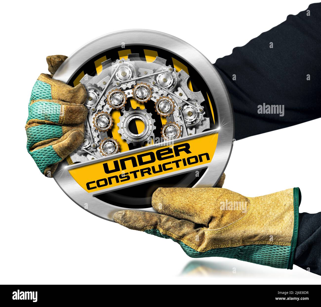 Gloved hands holding an under construction sign with metal cogwheels ...