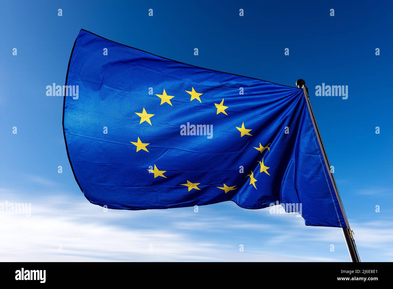 Close-up of an European Union flag waving against a clear blue sky with ...