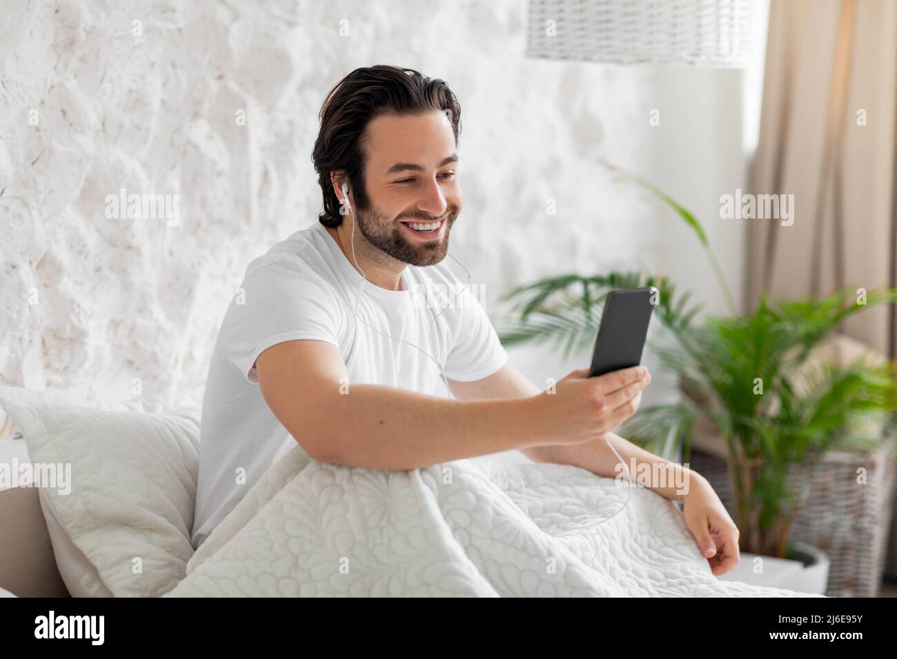 Positive handsome guy having video call in the morning Stock Photo - Alamy