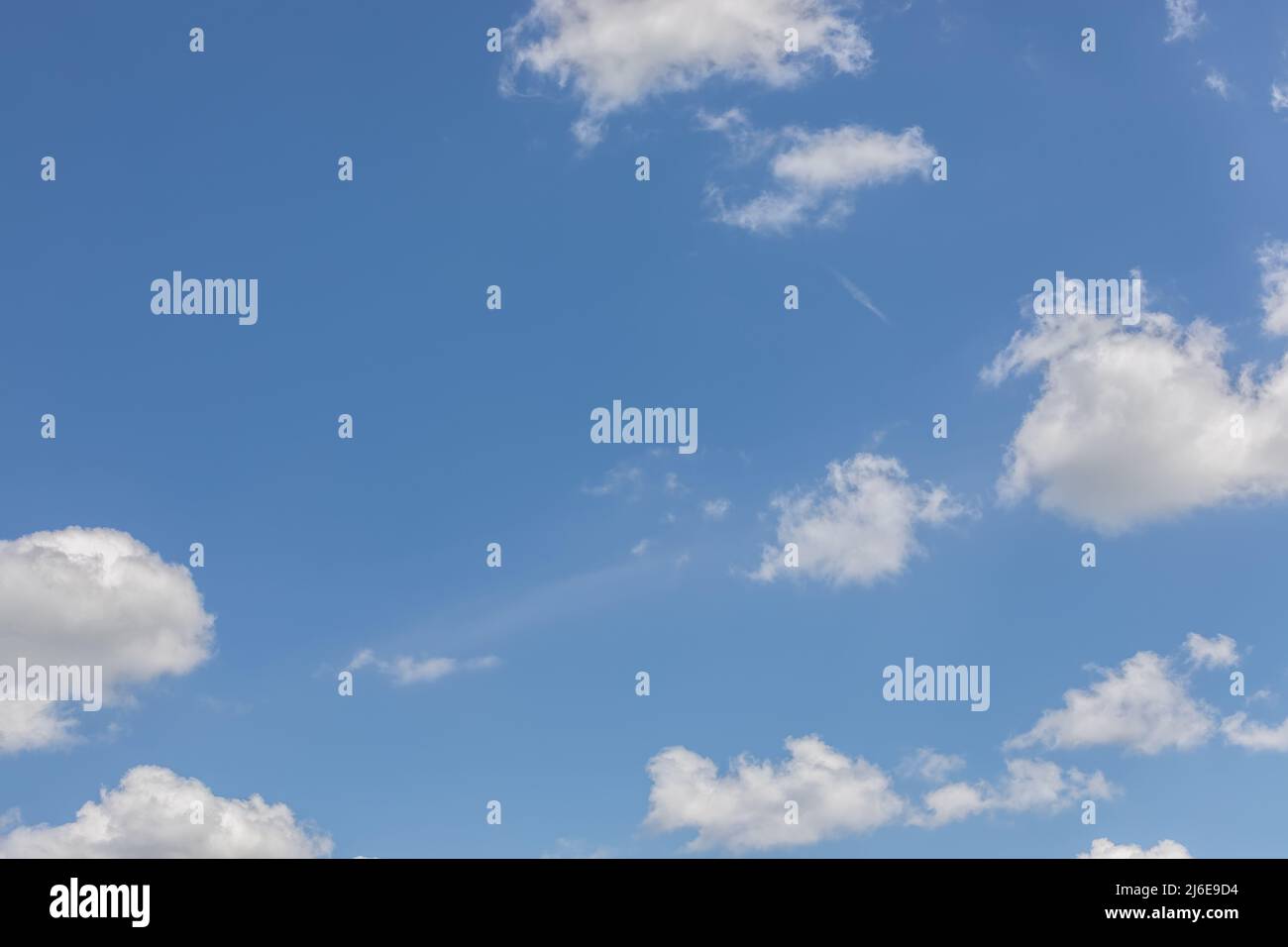 Fluffy isolated white clouds on a pale blue summer midday sky, ideal ...