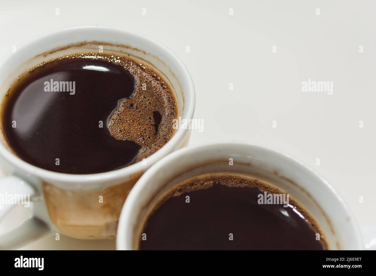 2 coffee cups on a light background. Selective focus. Top view at an ...