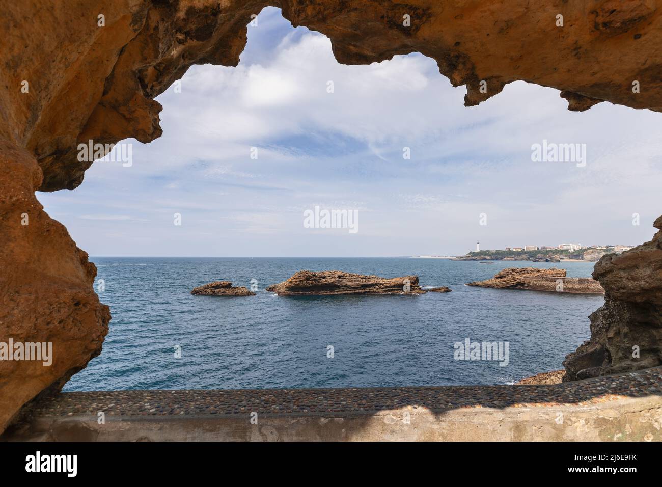 Natural window in rock overlooking sea washed out by sea water and ...