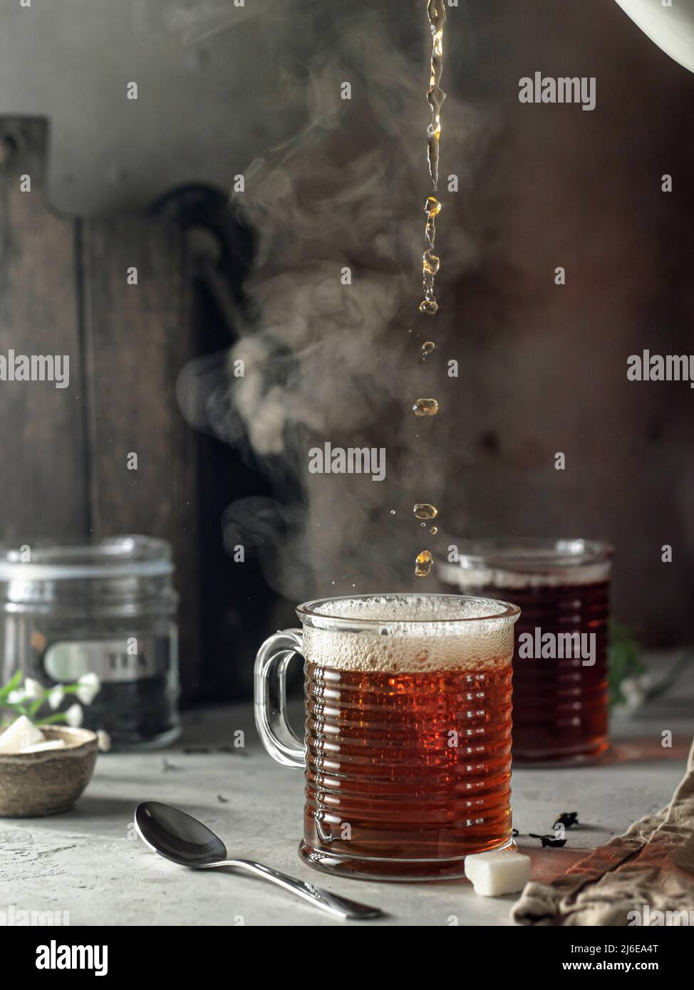 Still life with black tea poured into glass. with steam. Process ...