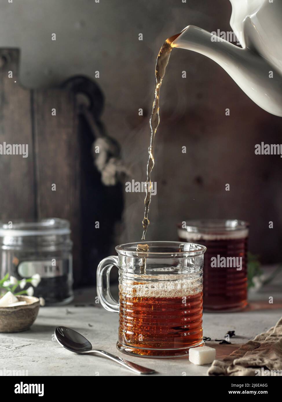 Still life with black tea poured into glass. with steam. Process ...