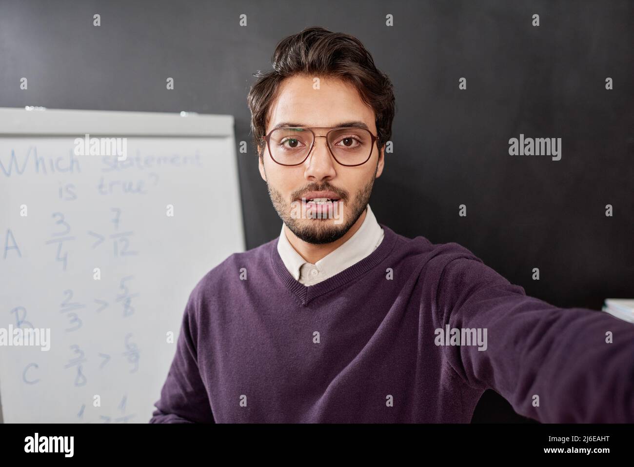 Portrait of young bearded school teacher in round-shaped eyeglasses ...