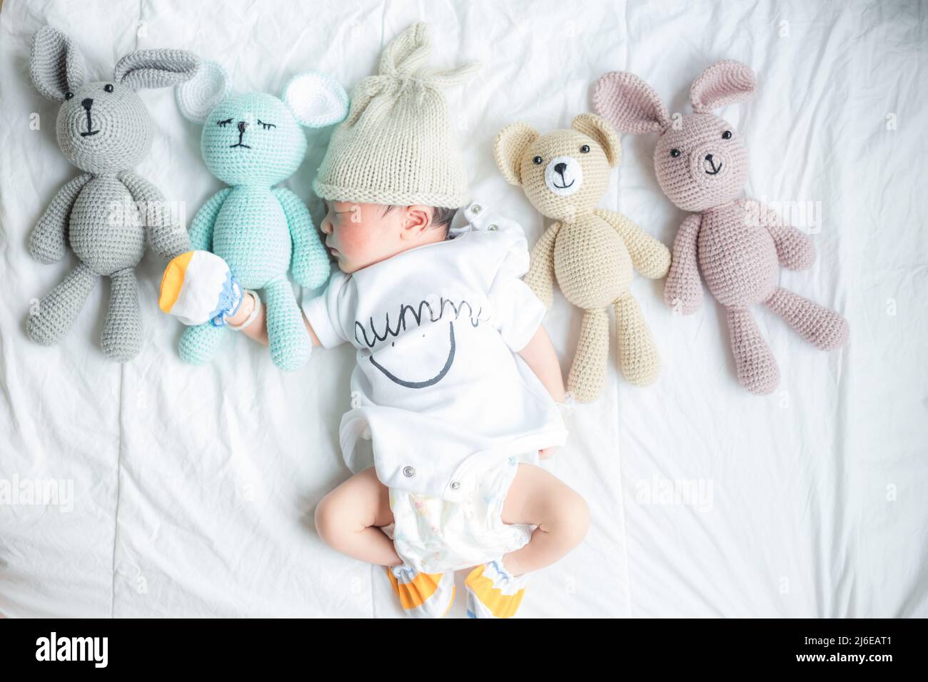 Adorable baby boy sleeping with many cute doll top view Stock Photo - Alamy