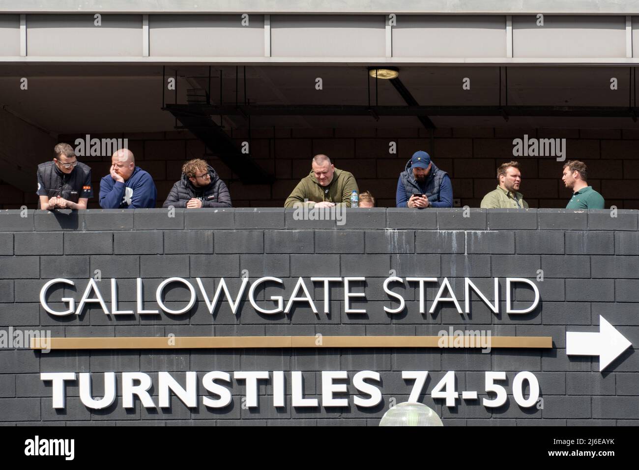 Football fans wait looking out from the back of the Gallowgate Stand of ...