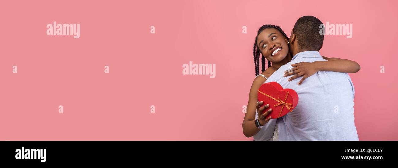 Black man making surprise for woman giving box, couple hugging Stock ...