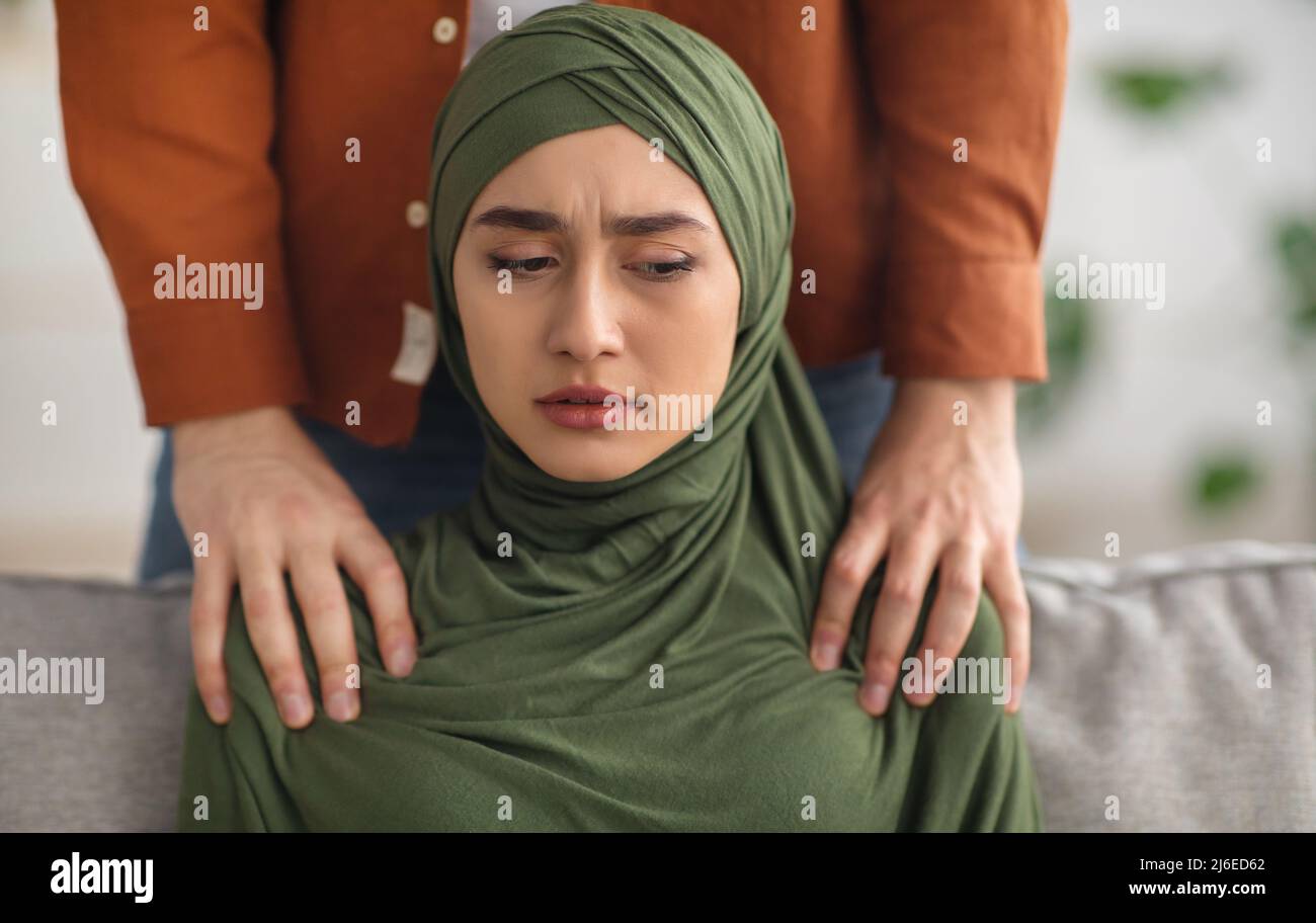Unrecognizable Muslim Husband Touching Unhappy Wife's Shoulders Indoors ...